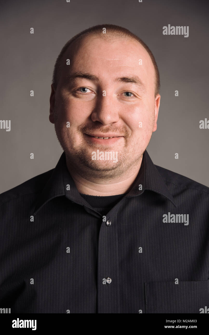Colored portrait of handsome smiling man isolated on gray studio ...