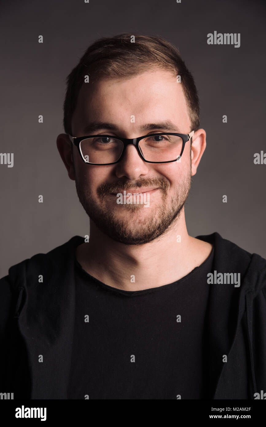 Colored portrait of handsome smiling man isolated on gray studio ...