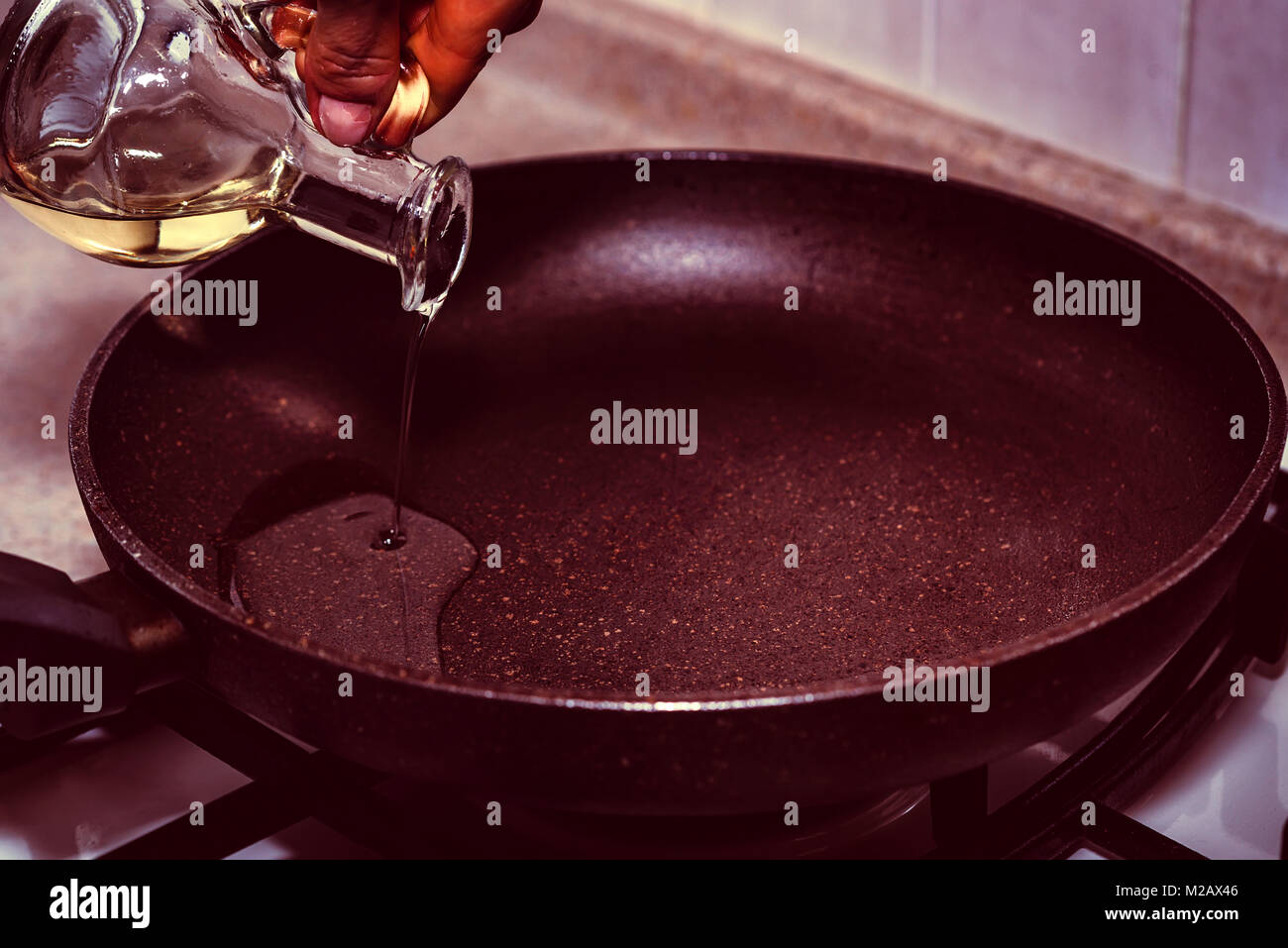 Pouring oil on frying pan Stock Photo - Alamy
