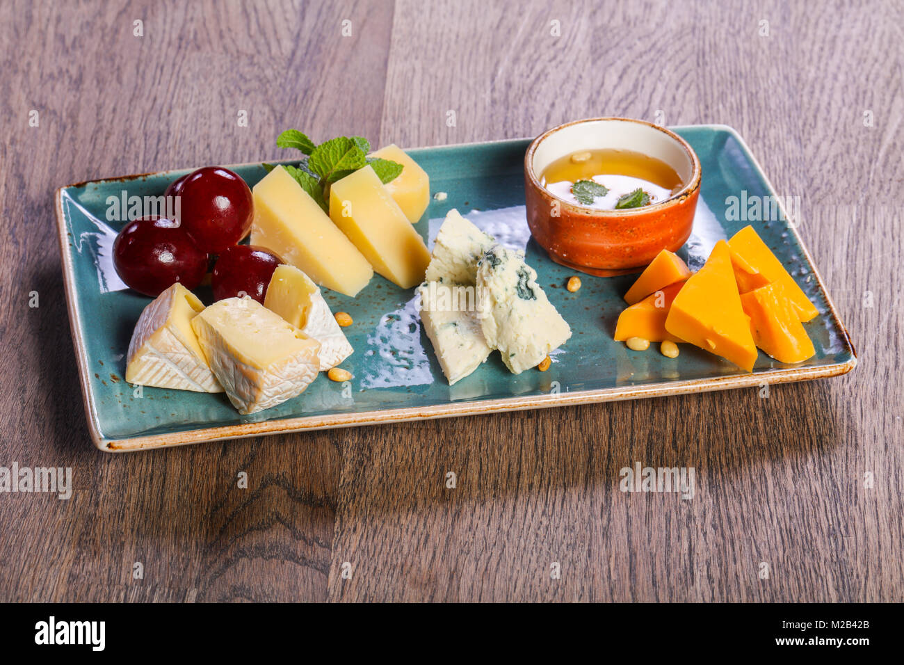 Cheese plate mix assortment with grape and honey Stock Photo - Alamy