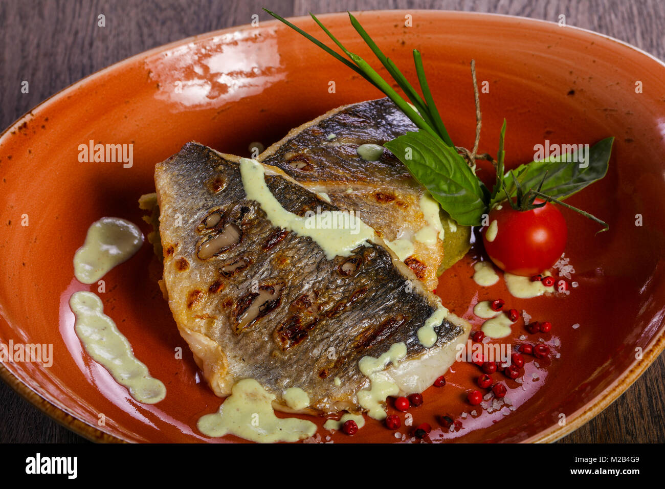Grilled dorada fillet served tomato and onion Stock Photo - Alamy