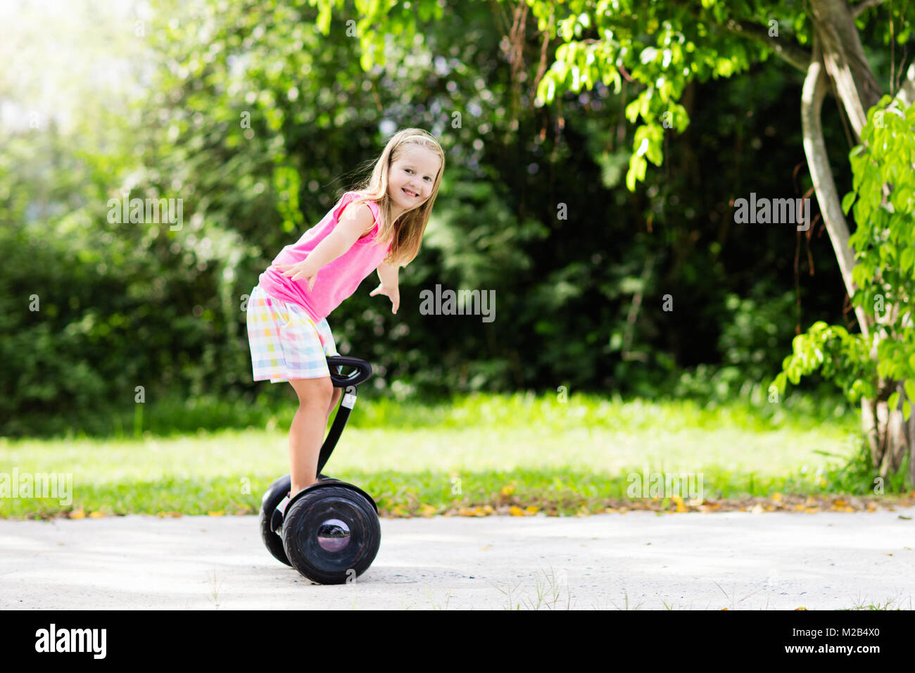Child on hover board. Kids riding scooter in summer park. Balance board ...