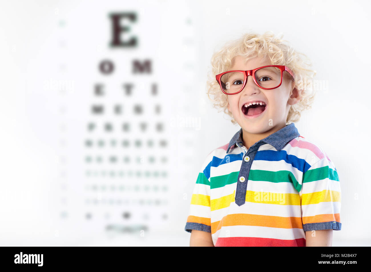 Child at eye sight test. Little kid selecting glasses at optician store ...