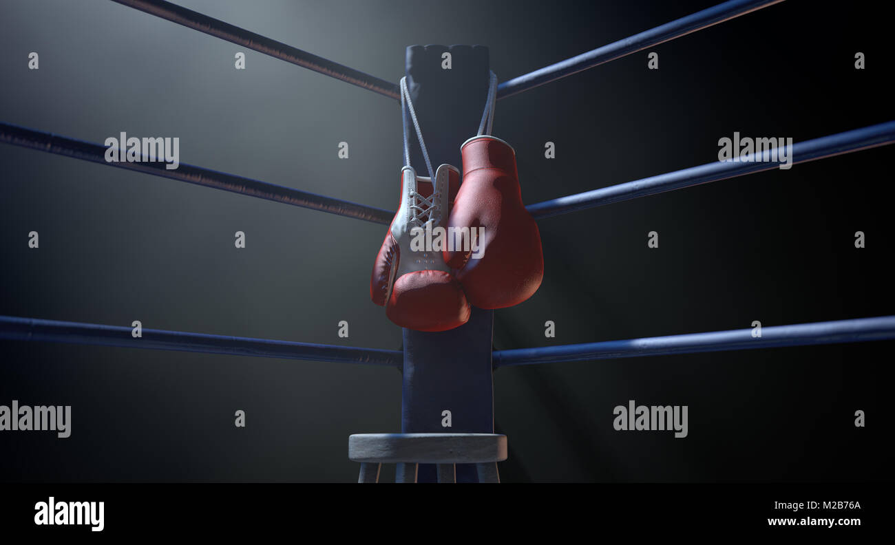 The blue corner of a boxing ring with gloves hanging on a pole spotlit ...