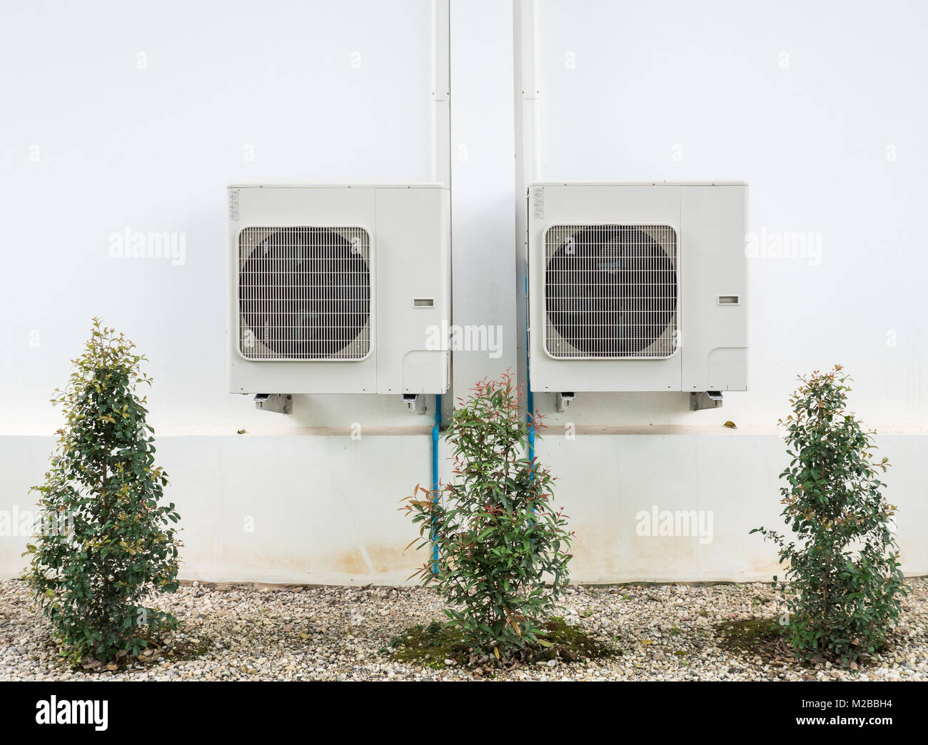 Twin air compressor unit is hanging on the white wall behind the office ...