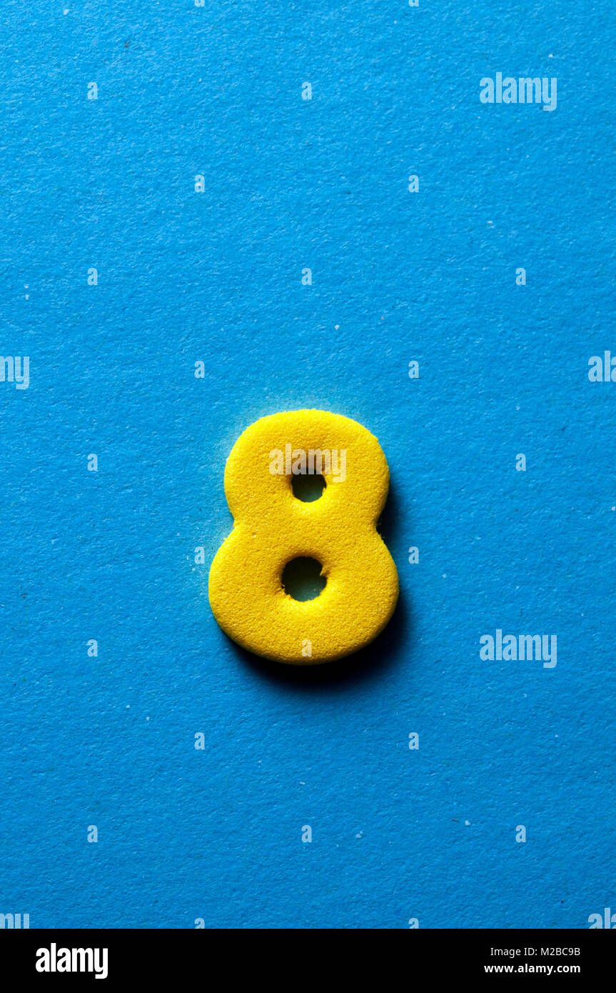 yellow number eight on blue background Stock Photo - Alamy