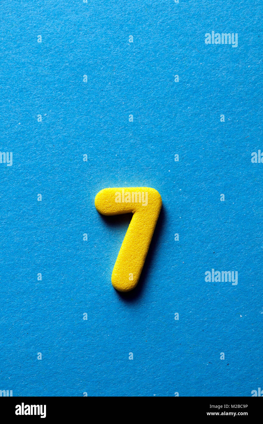 yellow number seven on blue background Stock Photo - Alamy