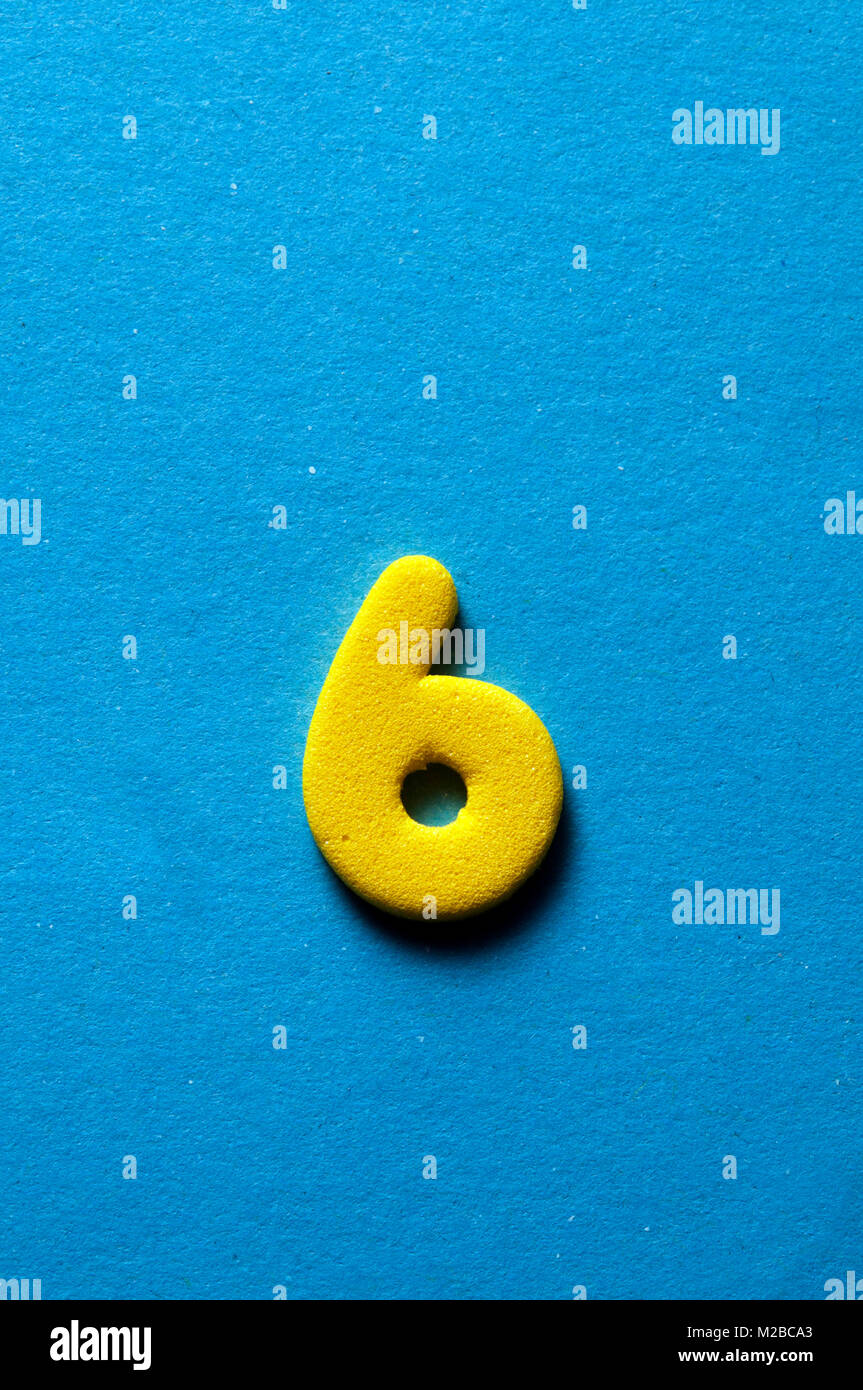 yellow number six on blue background Stock Photo - Alamy