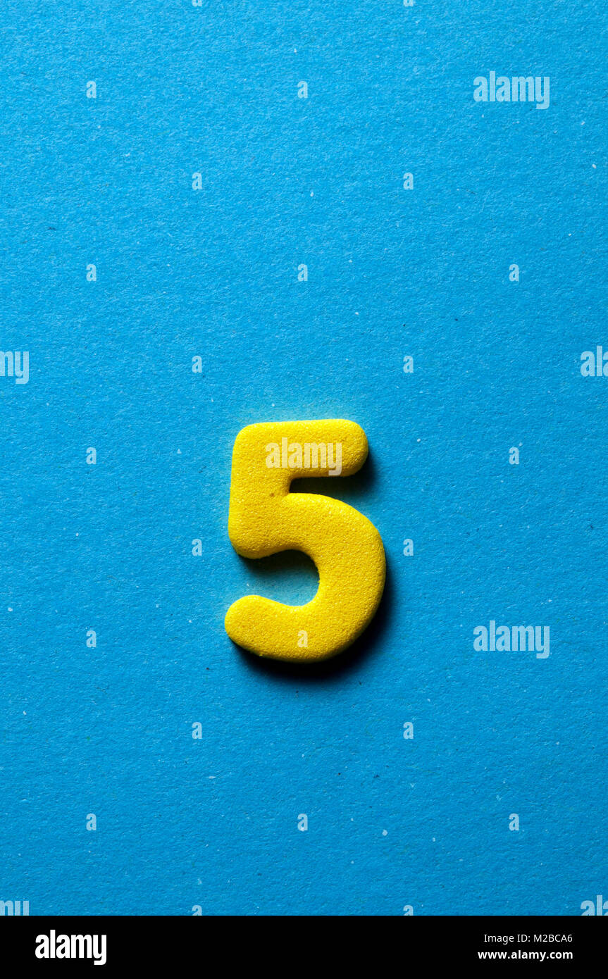 yellow number five on blue background Stock Photo - Alamy