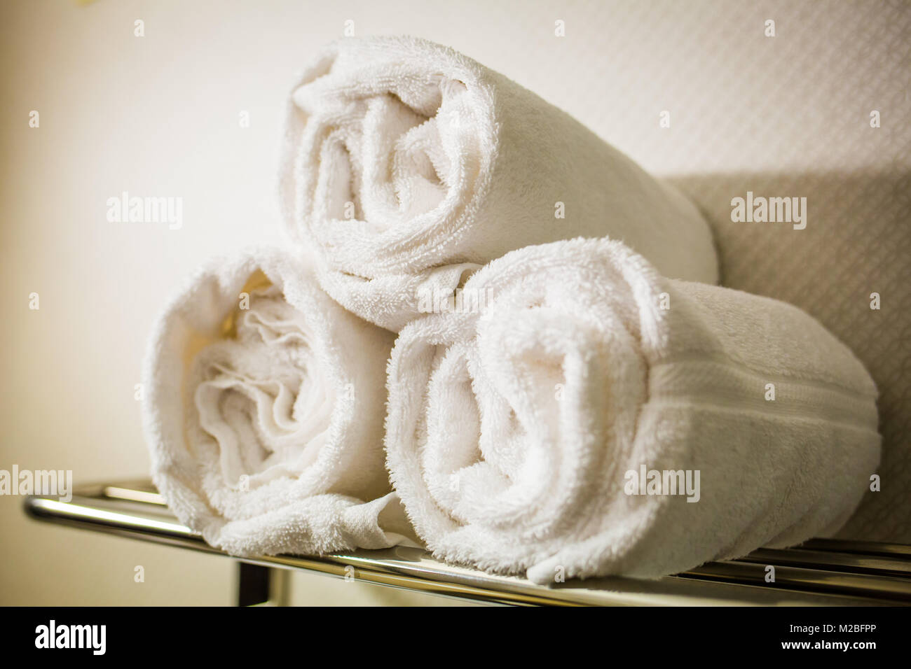 Rolled white towels on a shelf bathroom Stock Photo - Alamy