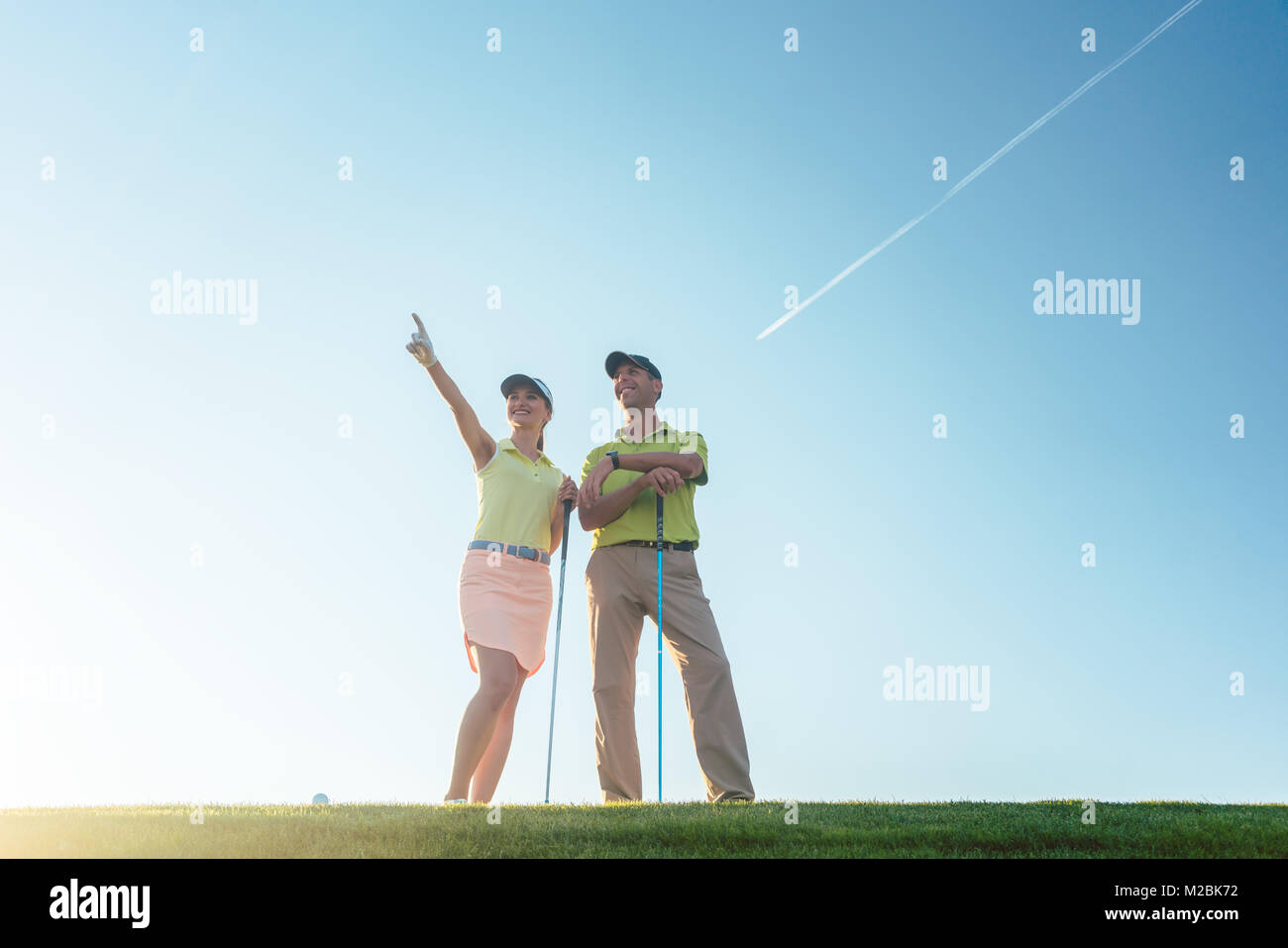 Low-angle view of the silhouette of a man pointing to the horizon ...