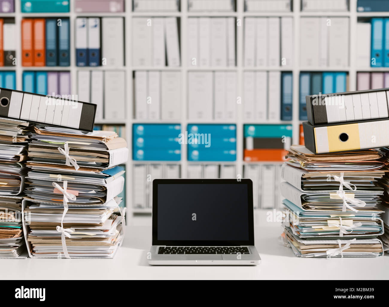 Piles of paperwork in the office and laptop on the desktop Stock Photo ...