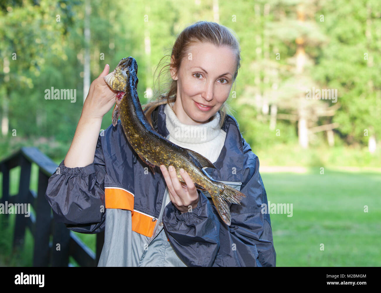 The woman holds the fish caught on fishing Stock Photo - Alamy