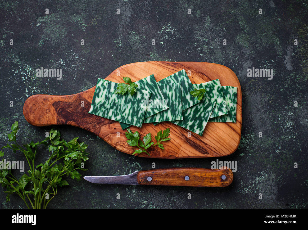 Green sliced cheese with herbs Stock Photo - Alamy