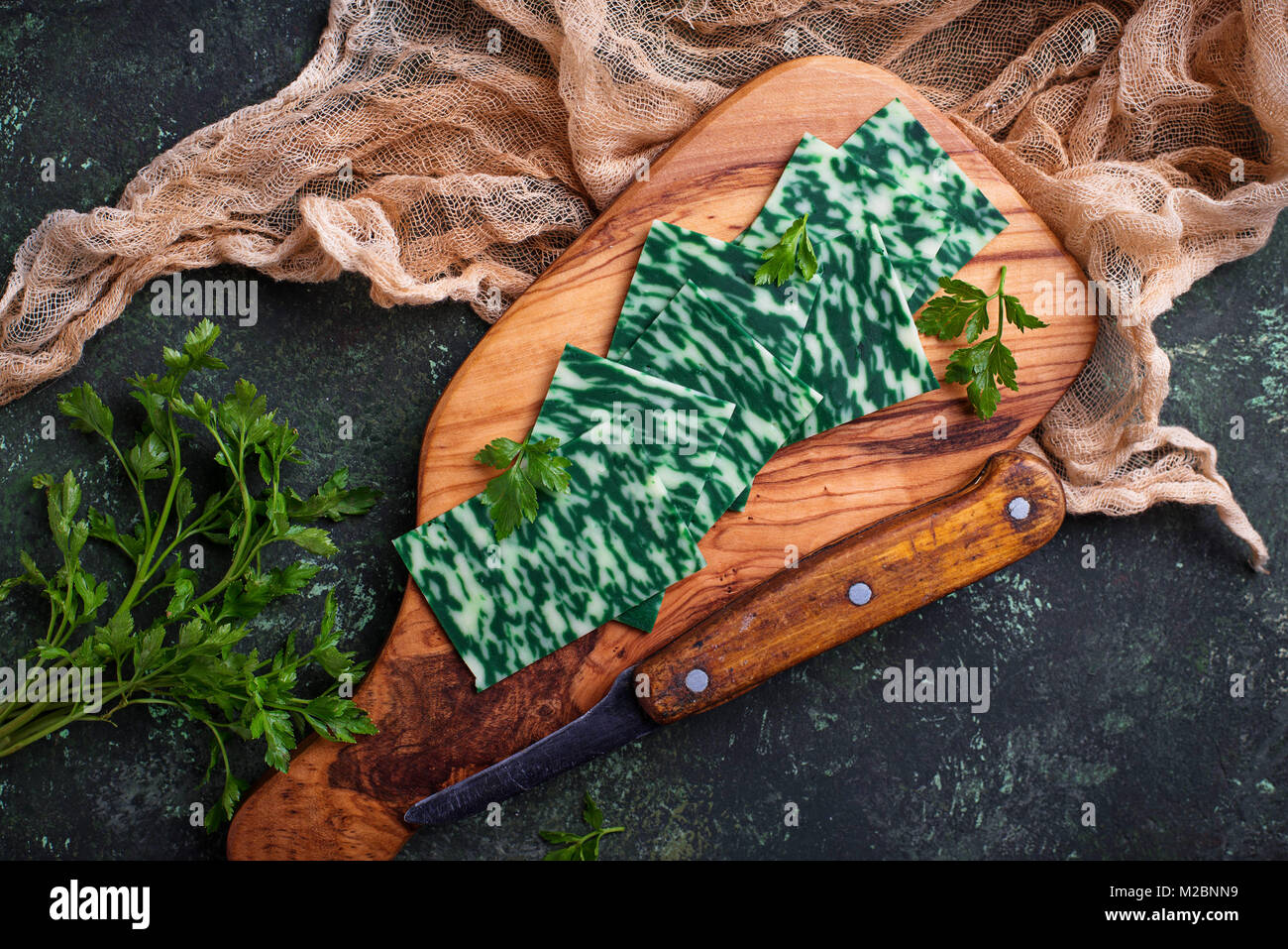 Green sliced cheese with herbs Stock Photo - Alamy