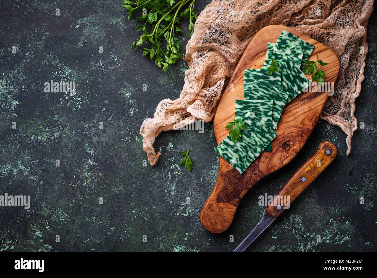 Green sliced cheese with herbs Stock Photo - Alamy