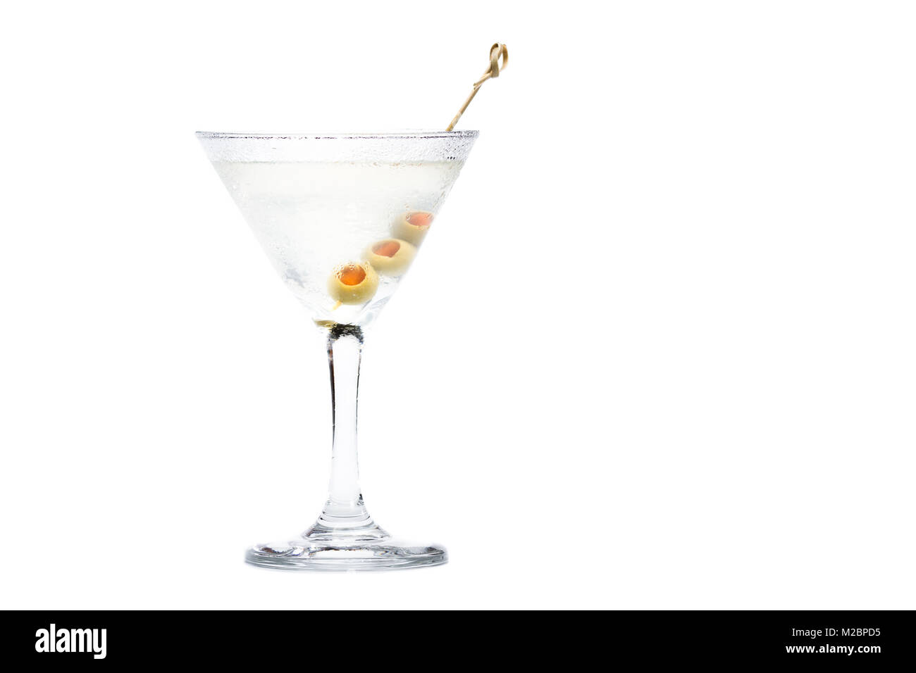 Freshly poured dirty vodka martini with green olives served on a ...