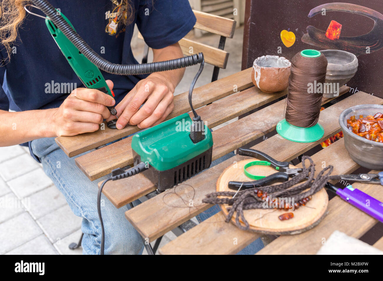 Artist engraver using an electric tool for stone engraving ornaments ...
