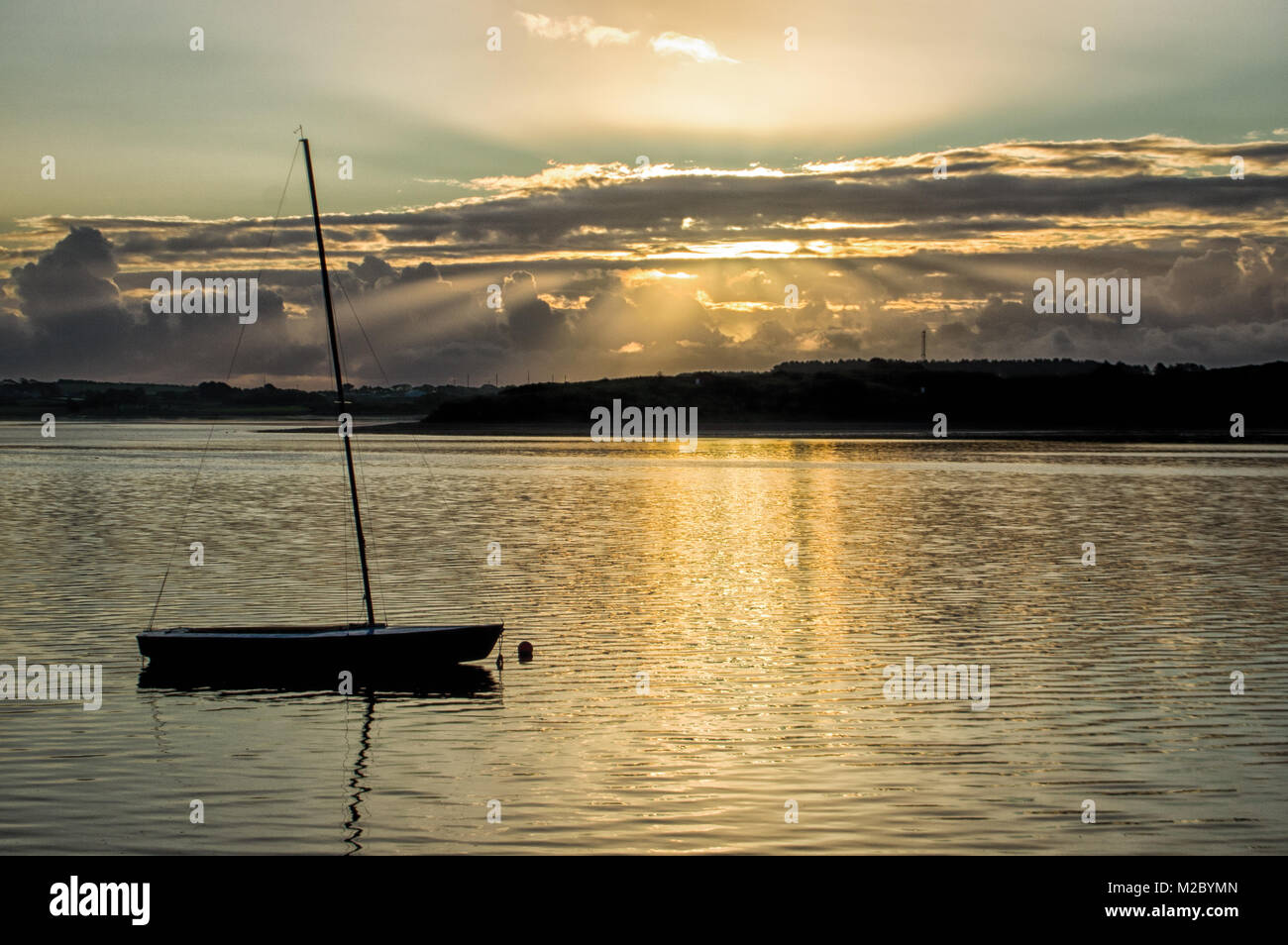 Sunrise with solitary boat Stock Photo - Alamy