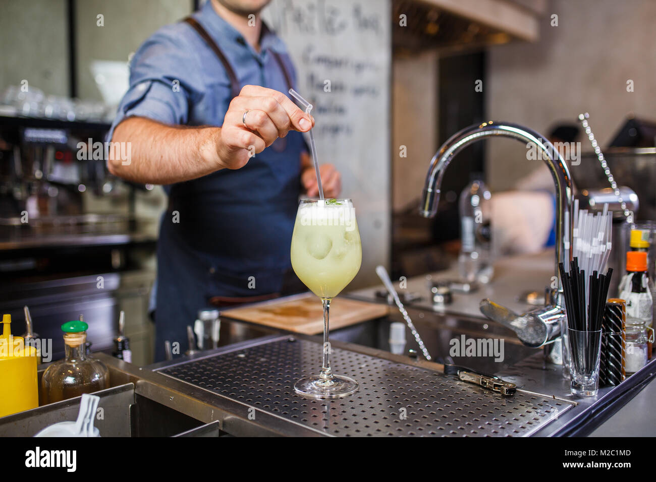 Bartender behind the bar preparing cocktails hi-res stock photography ...