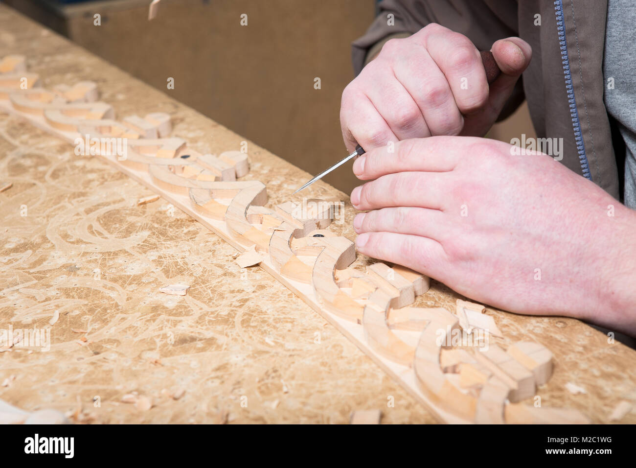 Artisan woodcarver creates a furniture ornament. Woodcarver's hands ...