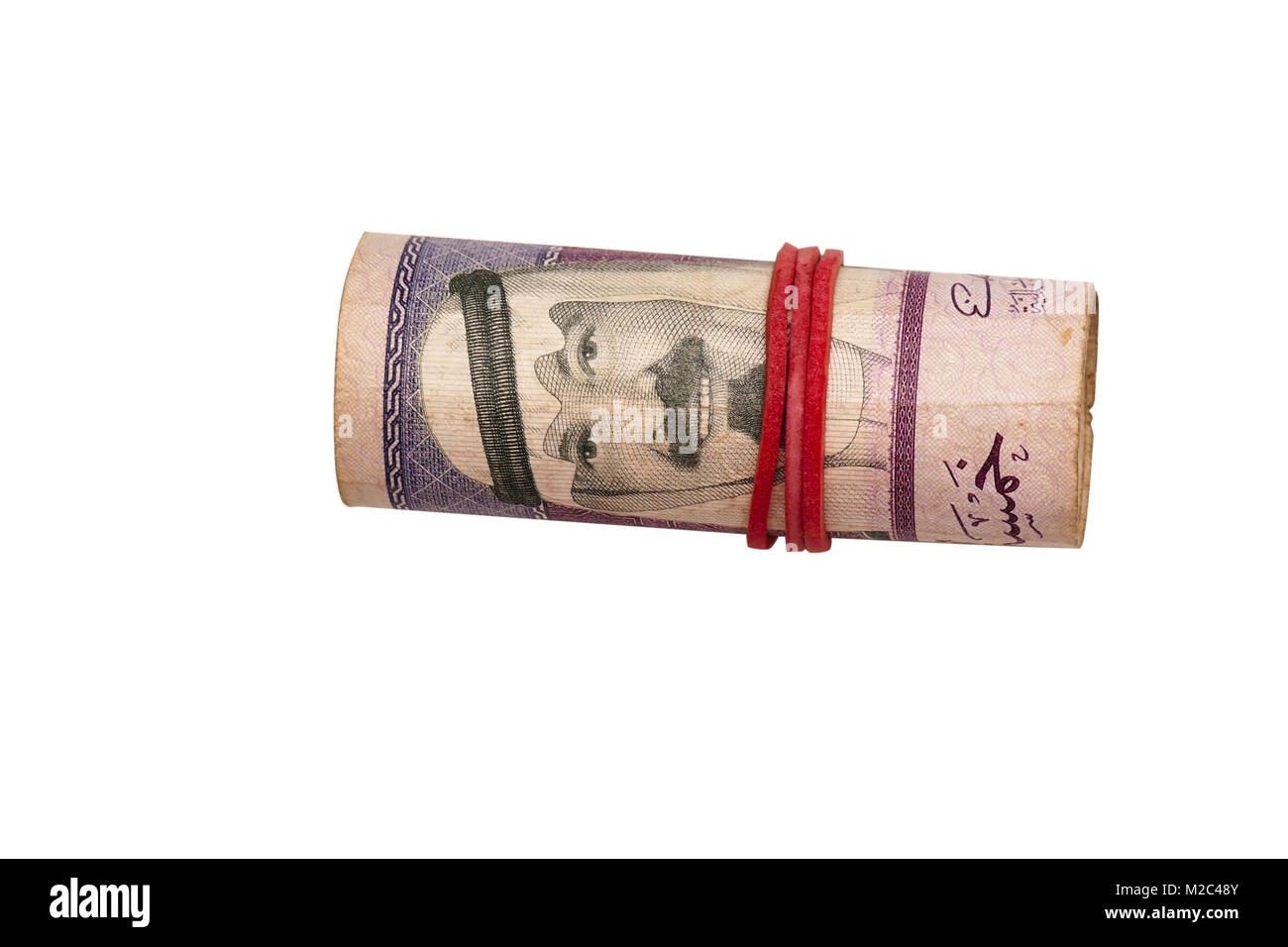 Rolled Saudi Arabian Riyal banknotes with a rubber ring, isolated on ...