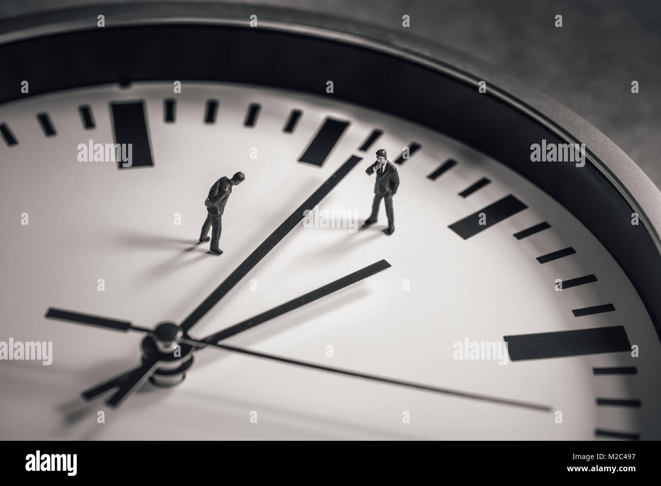 Two businessman standing in the middle of clock face. Business concept ...