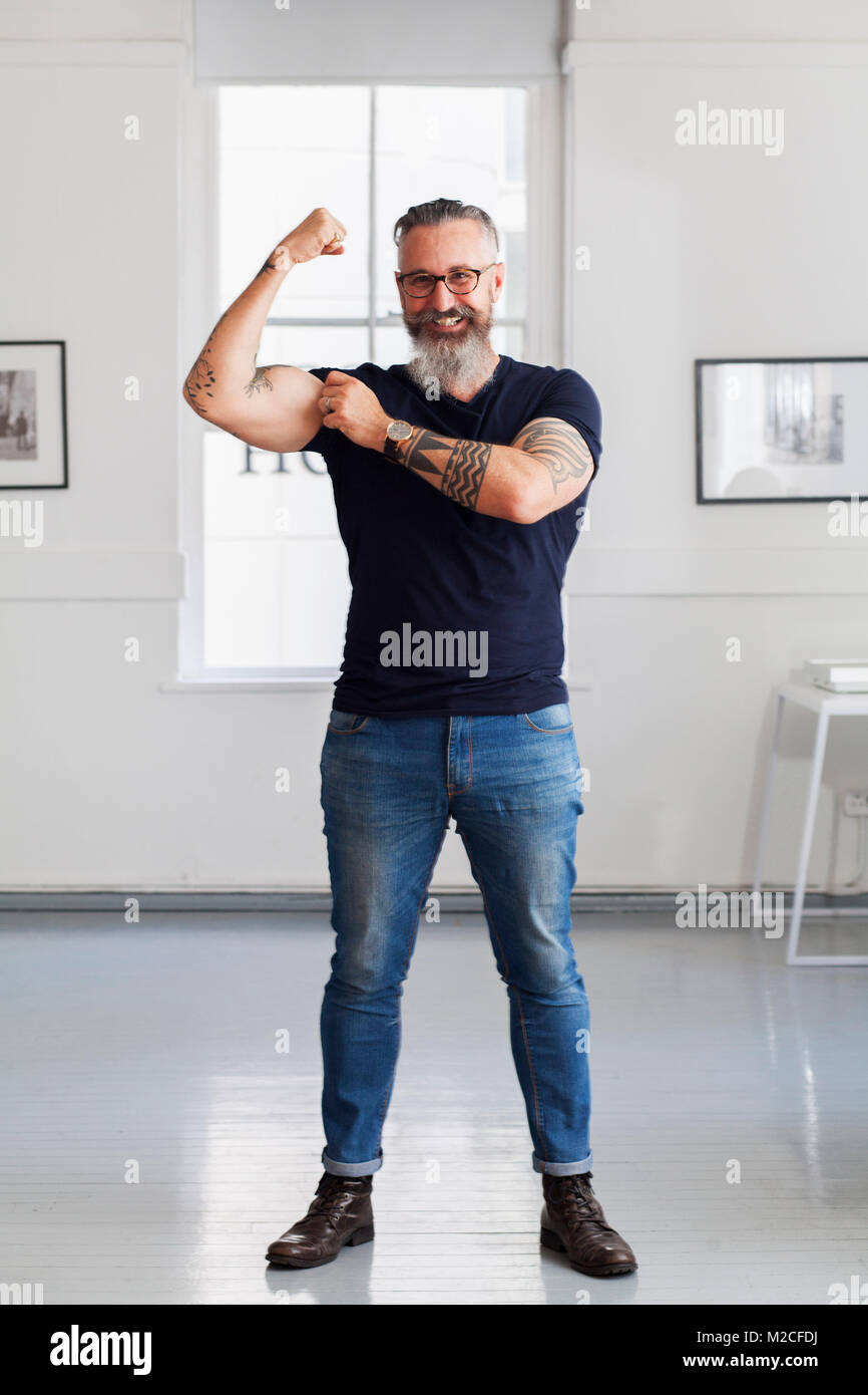 Smiling muscular Caucasian hipster man flexing biceps Stock Photo - Alamy