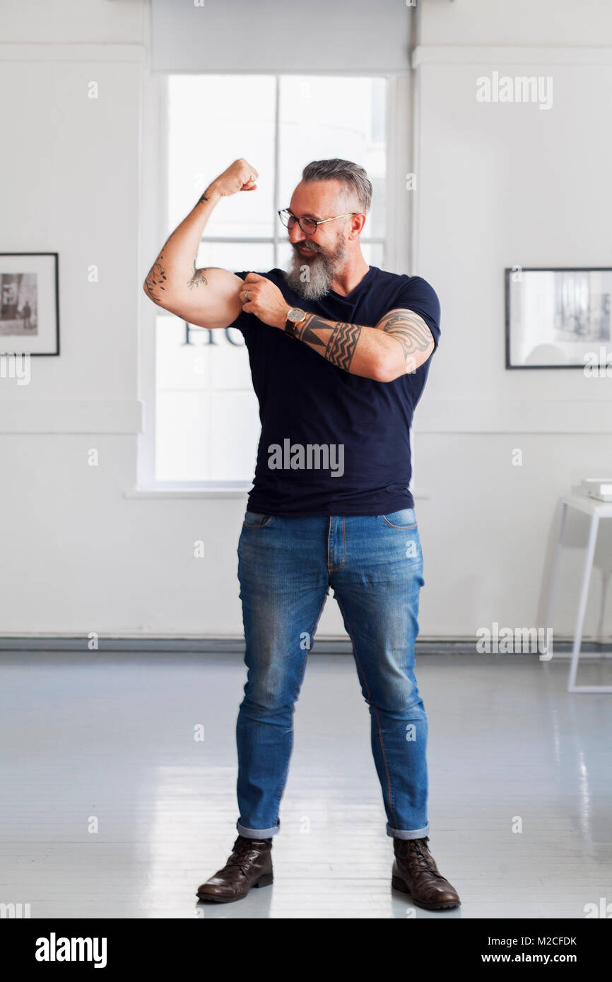 Smiling muscular Caucasian hipster man flexing biceps Stock Photo - Alamy