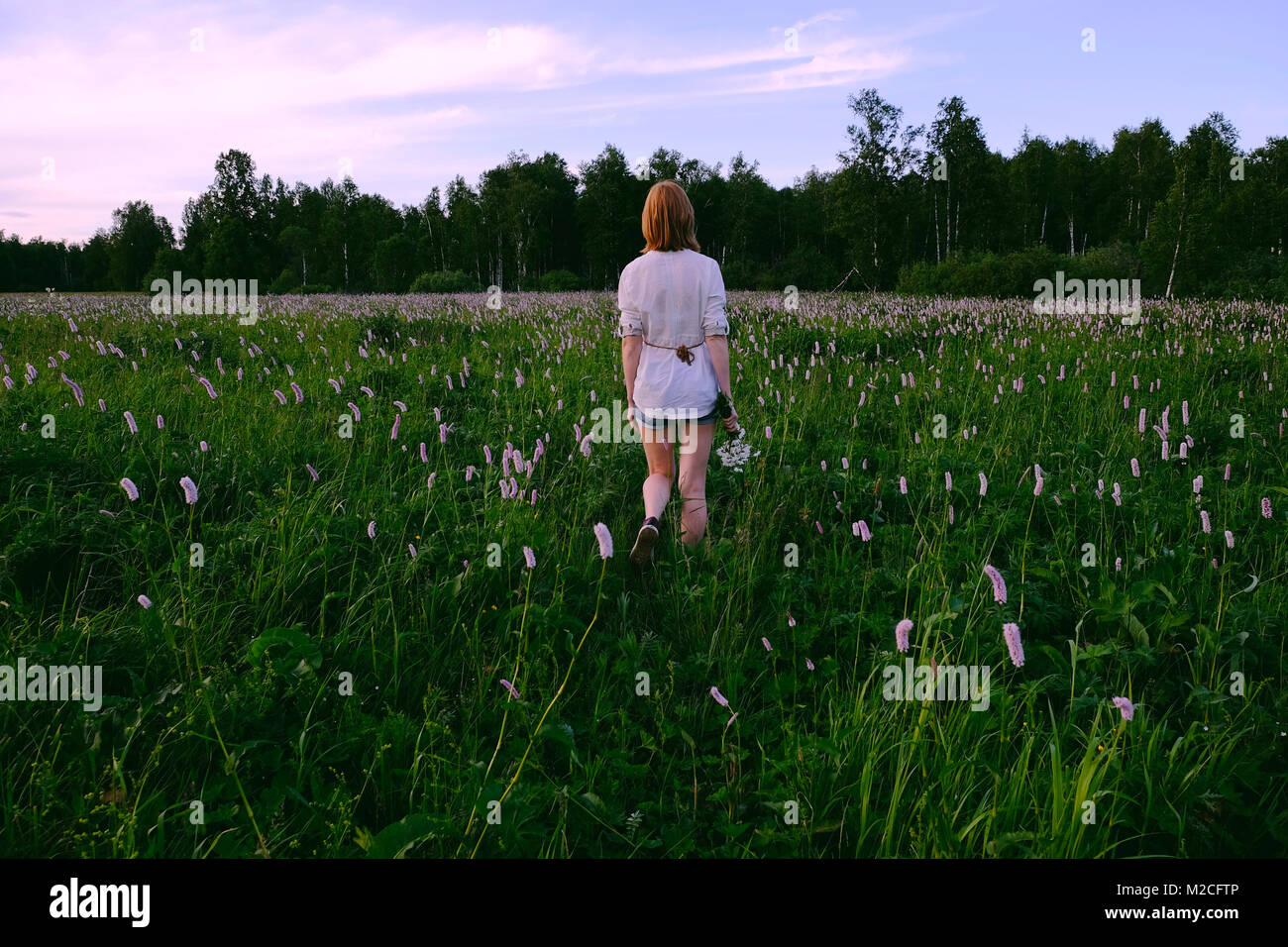 Woman walking in field Stock Photo - Alamy