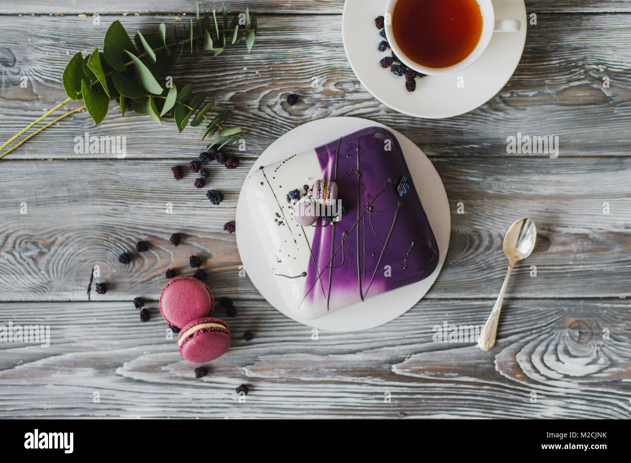 Hands going to eat dessert, yellow mousse cake with almond dacquoise ...