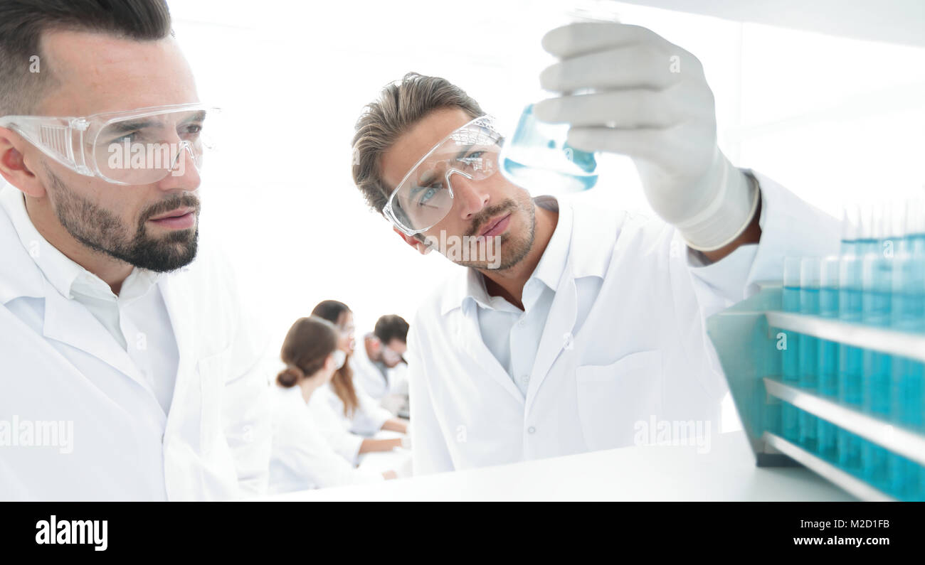 closeup. scientist and assistant studying the solution in the glass ...