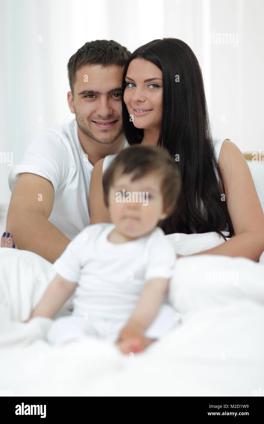 Cute little boy with parents on the bed Stock Photo - Alamy