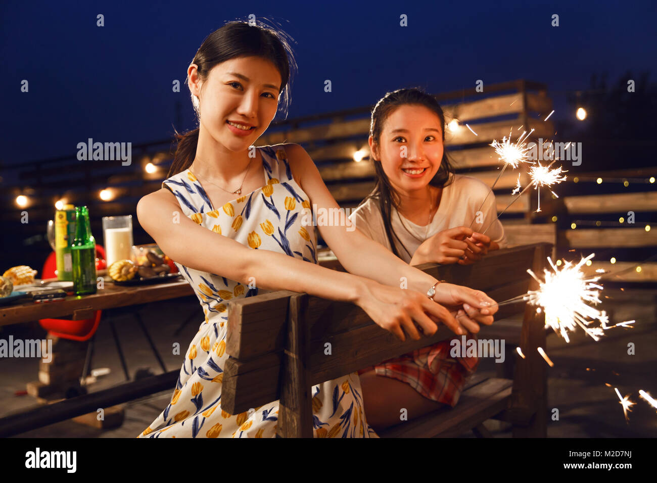 Two young women set off fireworks Stock Photo - Alamy