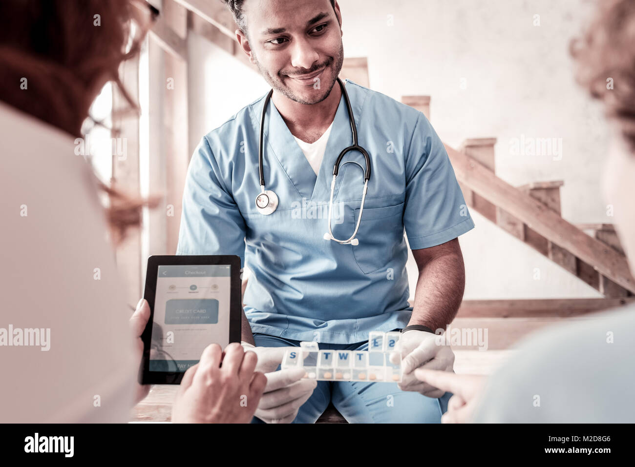 Cheerful doctor explaining patient his treatment method Stock Photo - Alamy