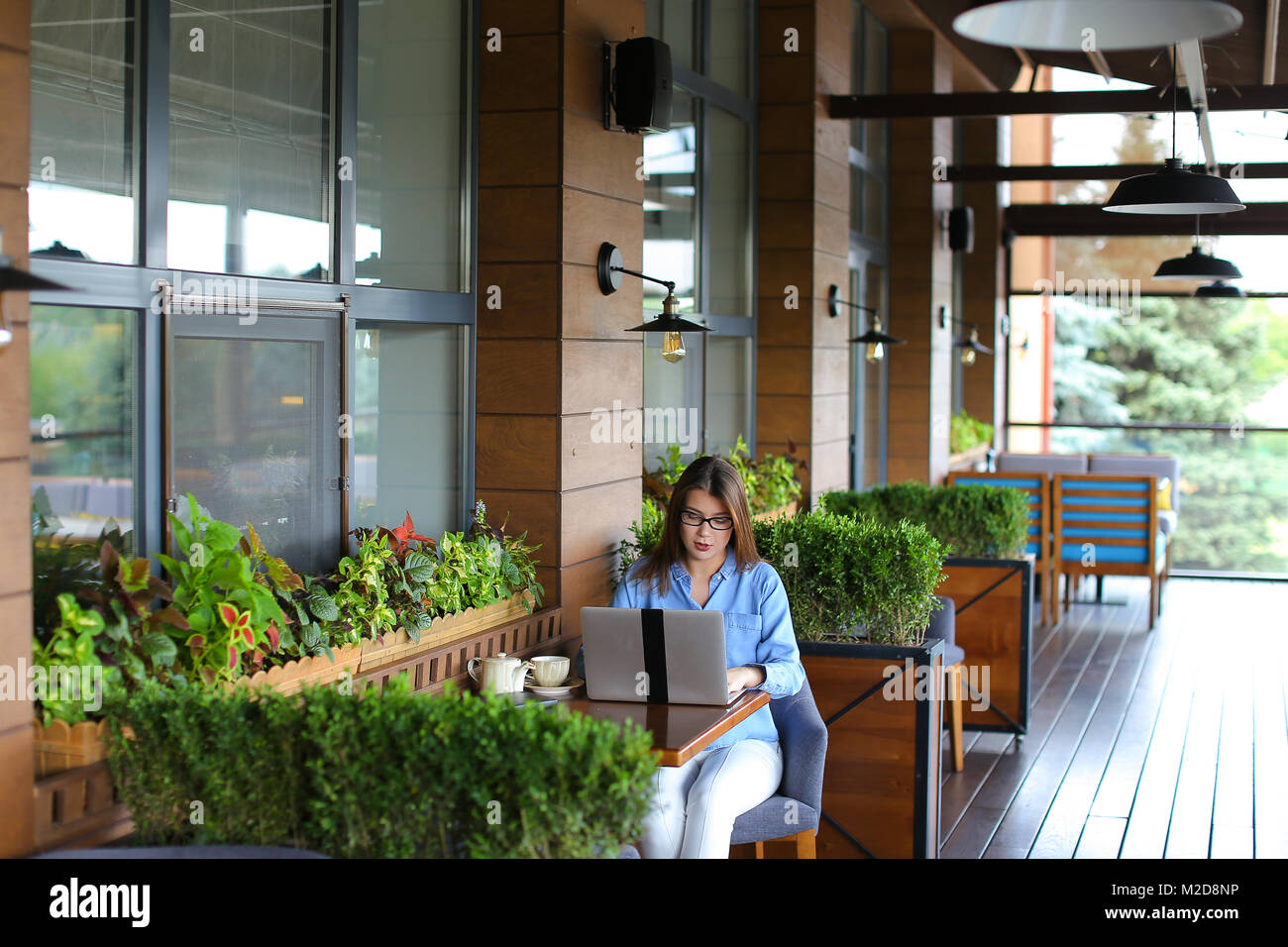Beautiful student working with laptop at restaurant Stock Photo - Alamy