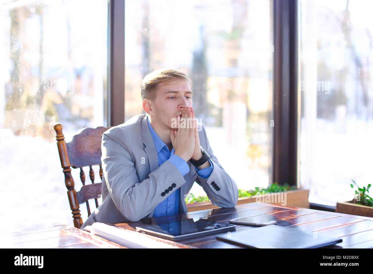 Tired young professor sitting at cafe with roll paper, smartphon Stock ...