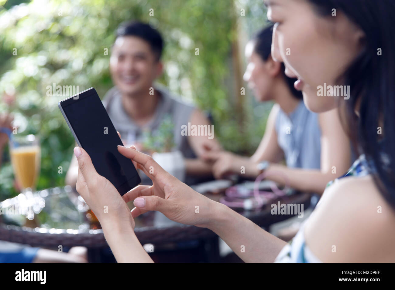 Young women watch mobile phones Stock Photo - Alamy