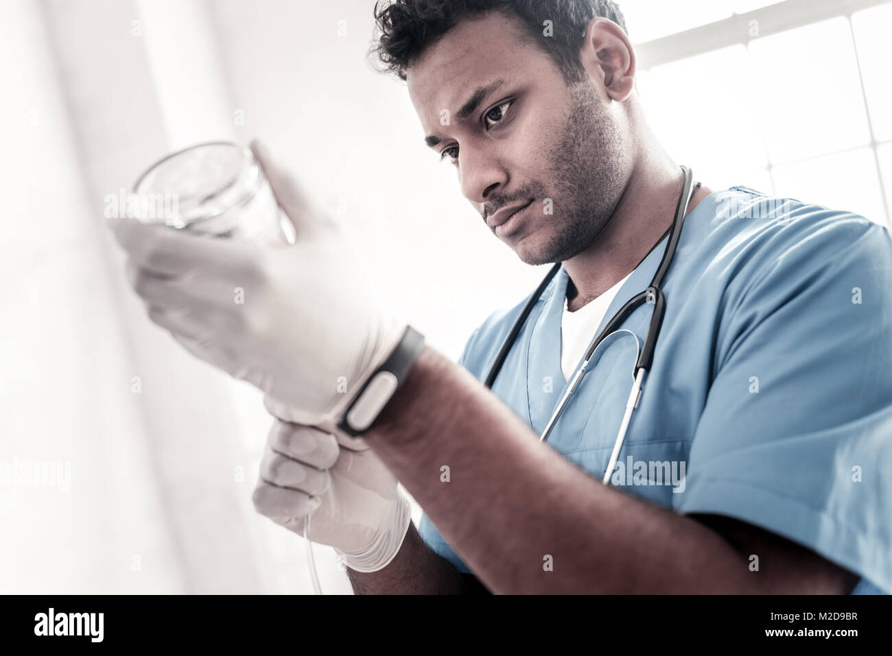 Focused doctor adjusting drip at hospital Stock Photo - Alamy