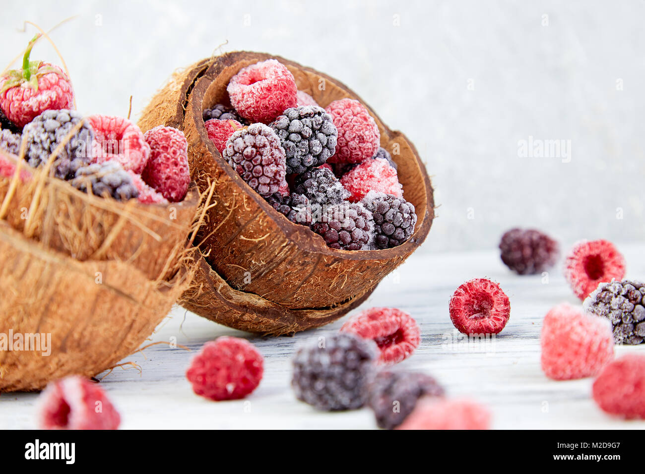 Frozen black and red raspberries in coconut bowl Stock Photo - Alamy