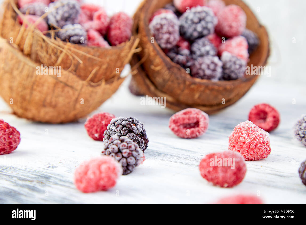 Frozen black and red raspberries in coconut bowl Stock Photo - Alamy