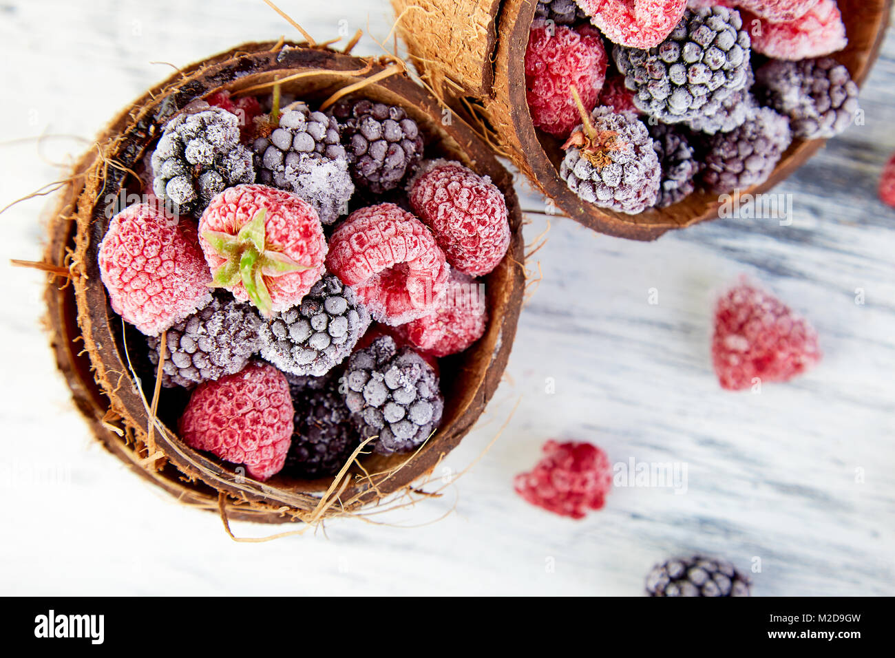 Frozen black and red raspberries in coconut bowl Stock Photo - Alamy