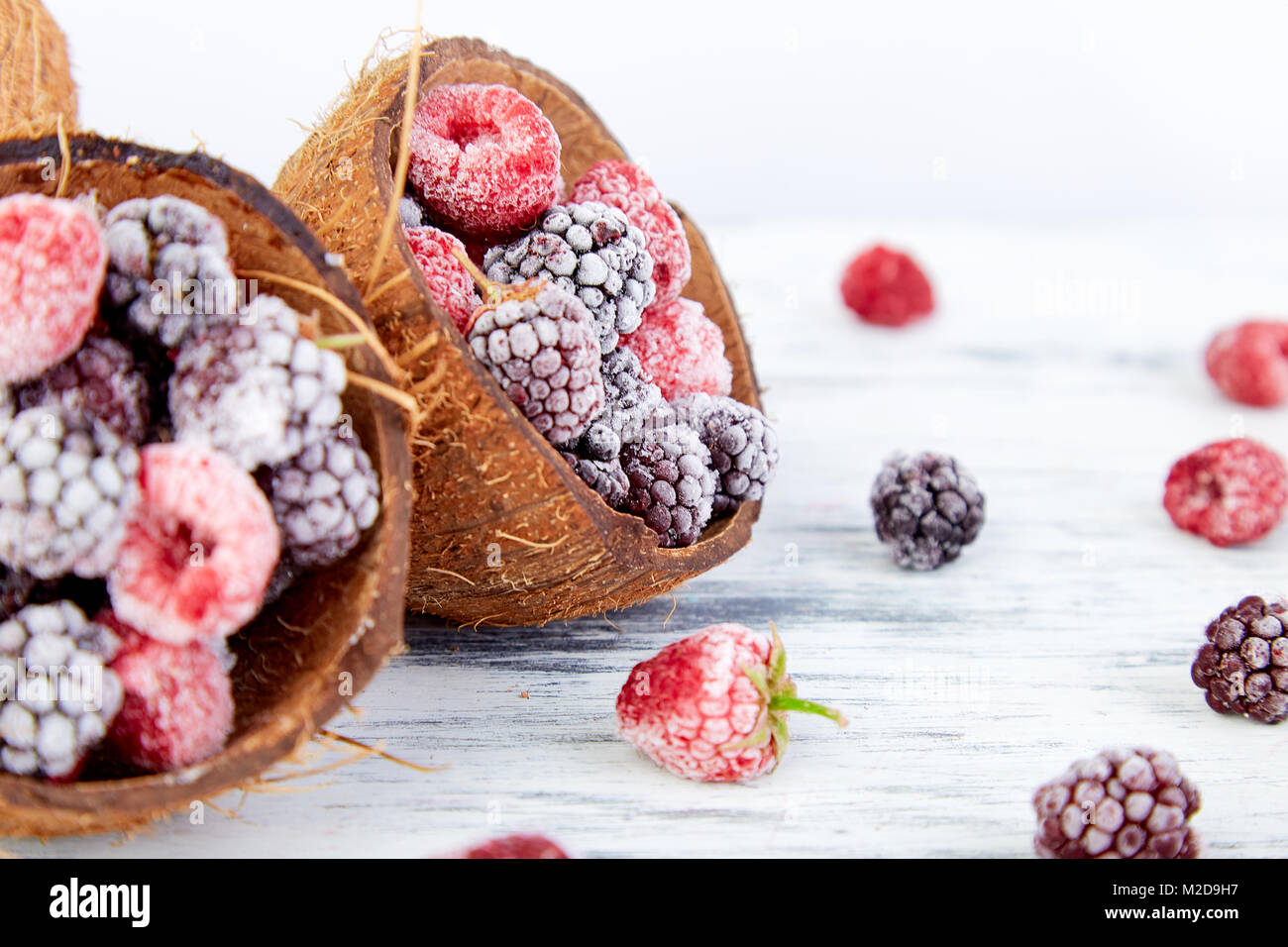 Frozen black and red raspberries in coconut bowl Stock Photo - Alamy