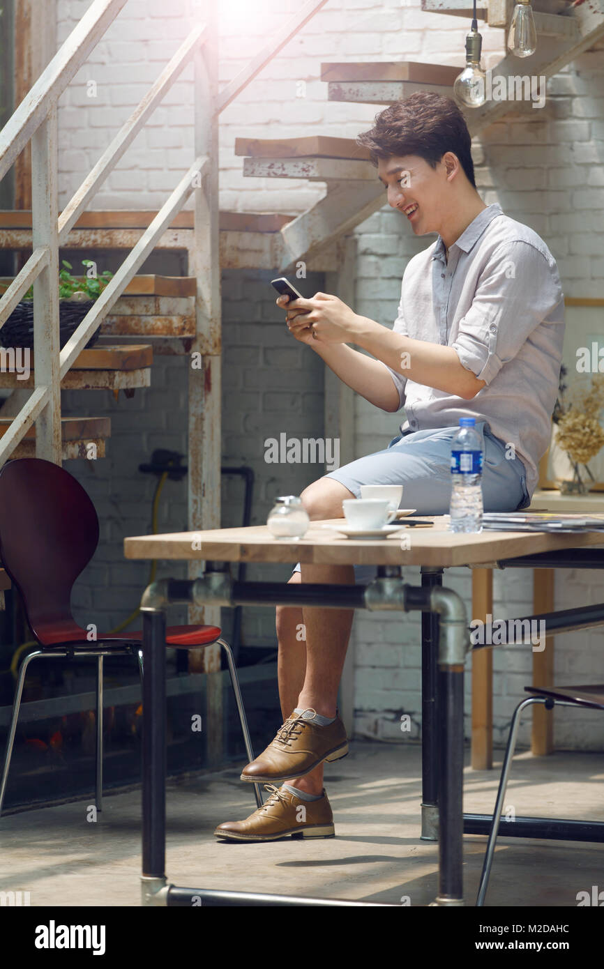 Young men watch mobile phones Stock Photo - Alamy
