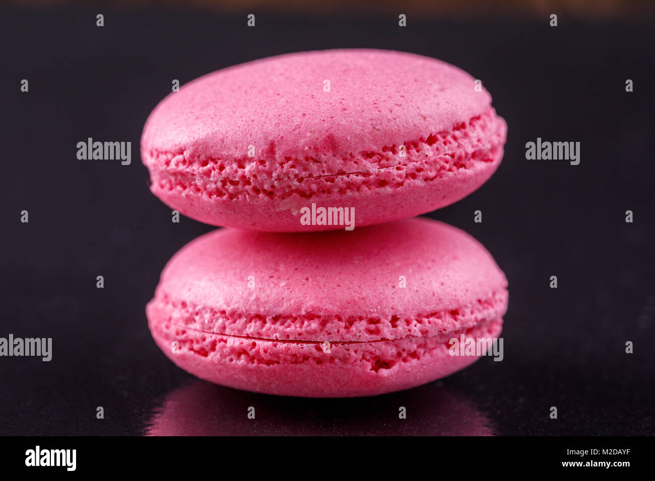 A pair of soft pink macaroons on a black background. Close-up Stock ...