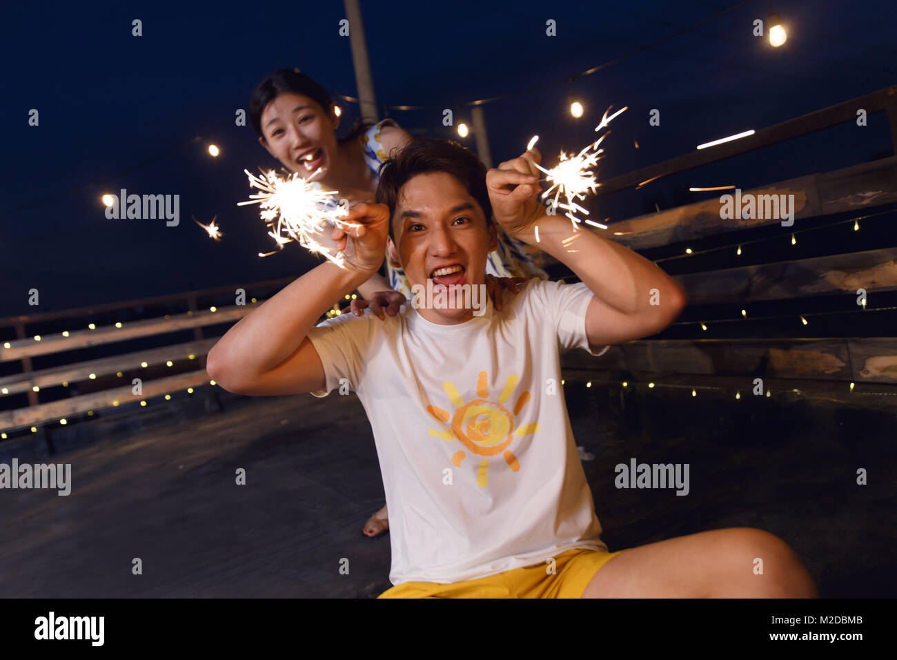 Young couples sit on a skateboard and set off fireworks Stock Photo - Alamy