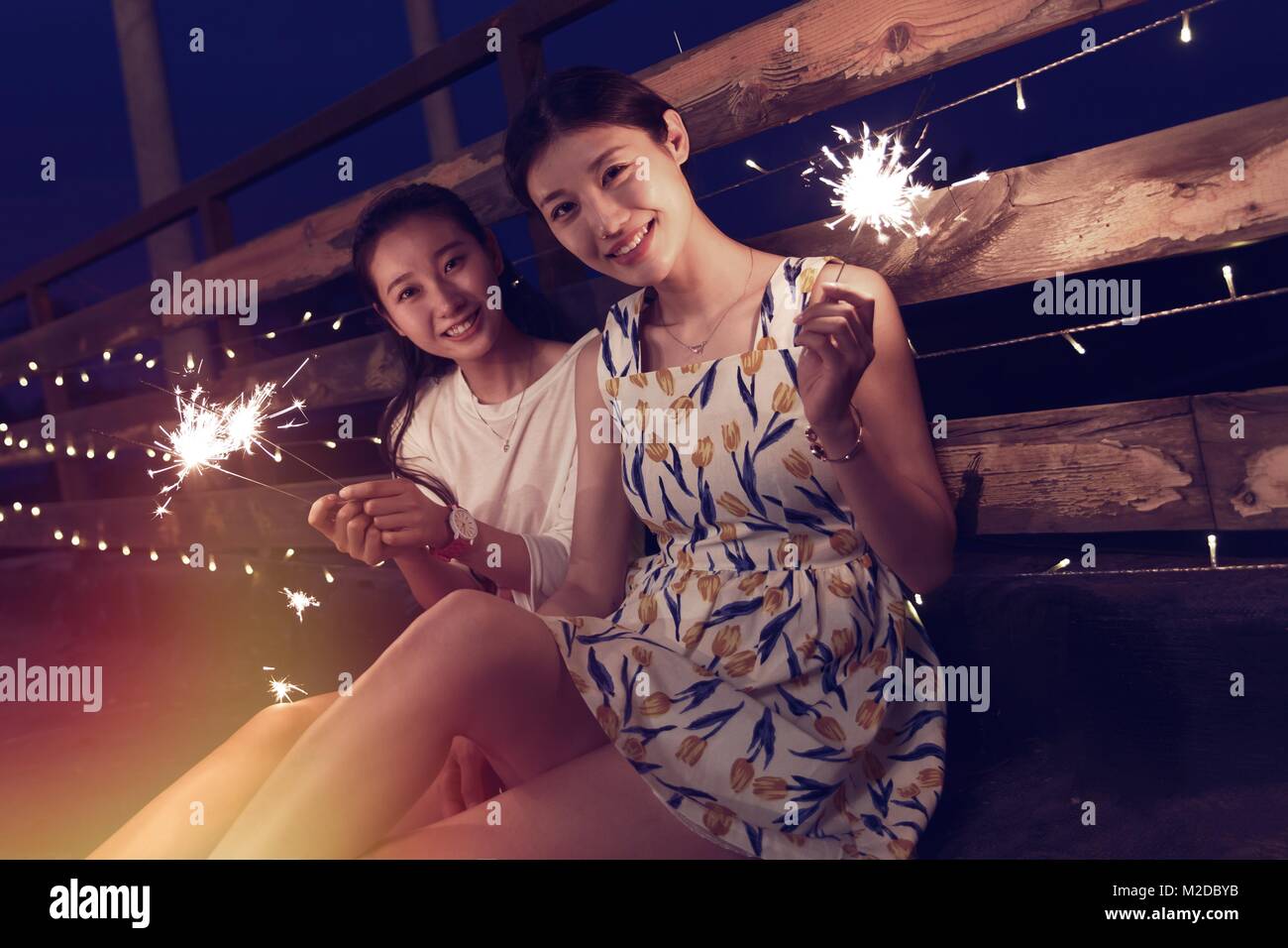 Two young women set off fireworks Stock Photo - Alamy