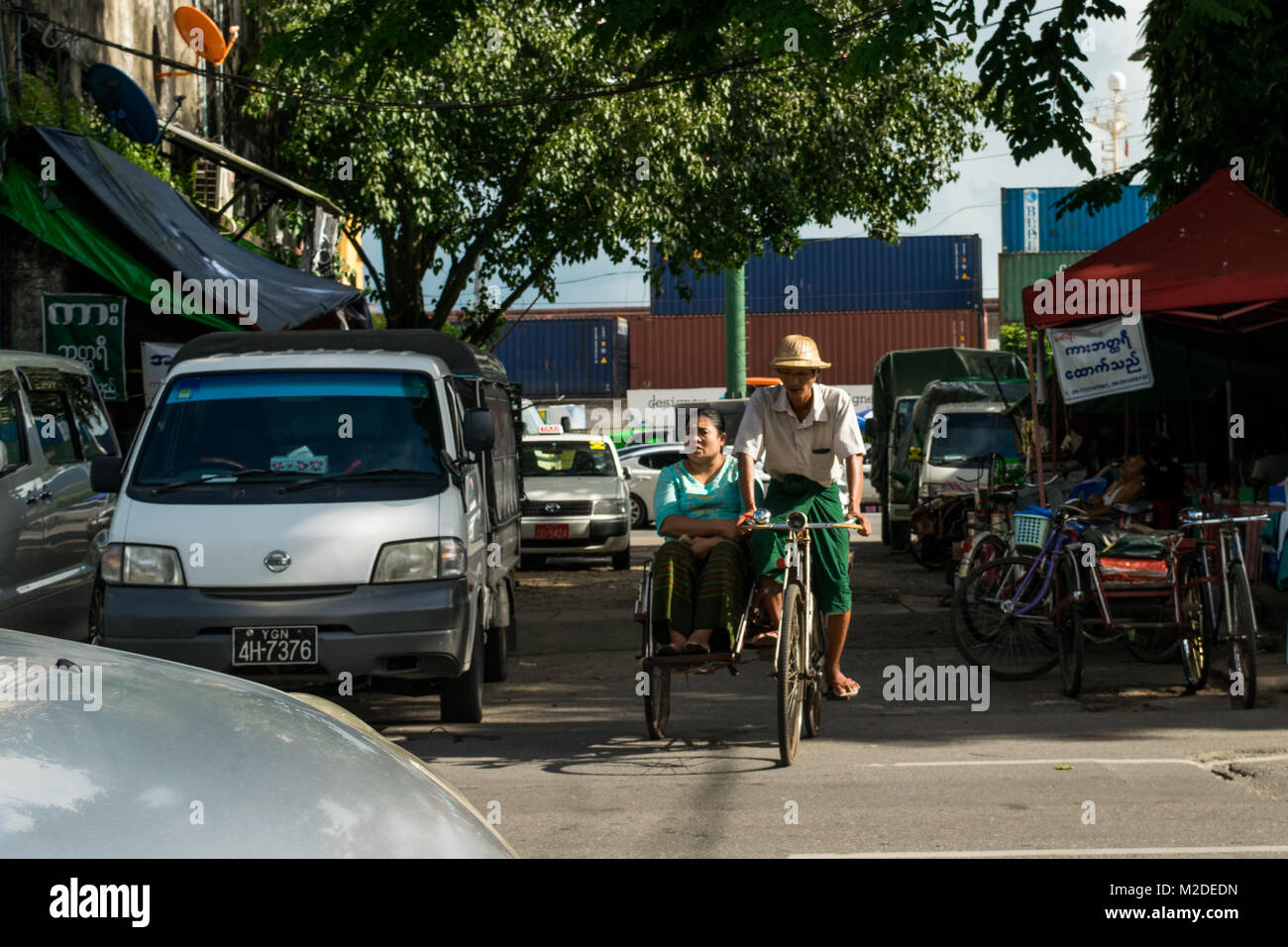 A Burmese couple, possibly husband and wife, with the man driving a ...