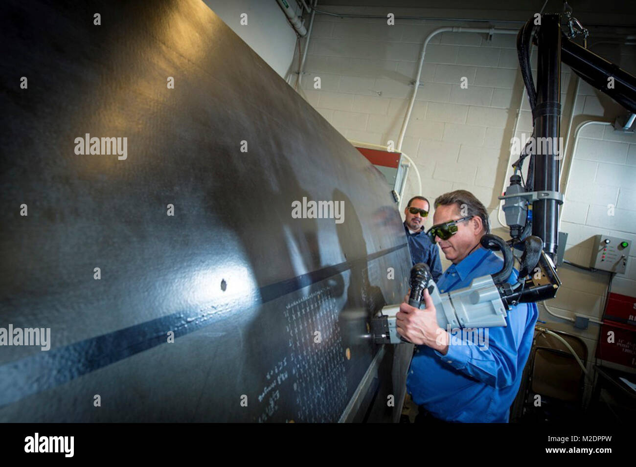 A researcher uses Laser Bond Inspection on a large structure at the ...