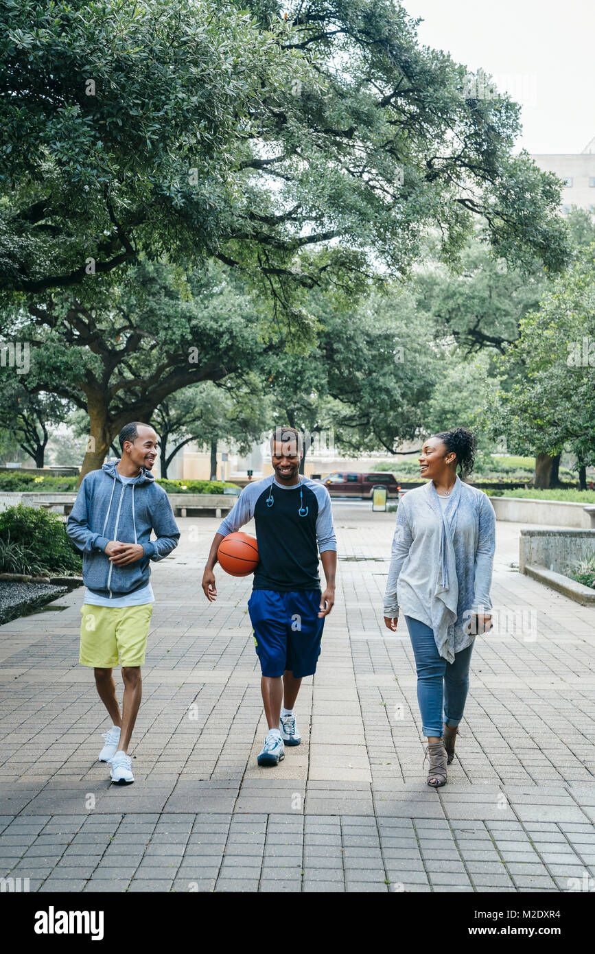Smiling Black friends walking in park with basketball Stock Photo - Alamy
